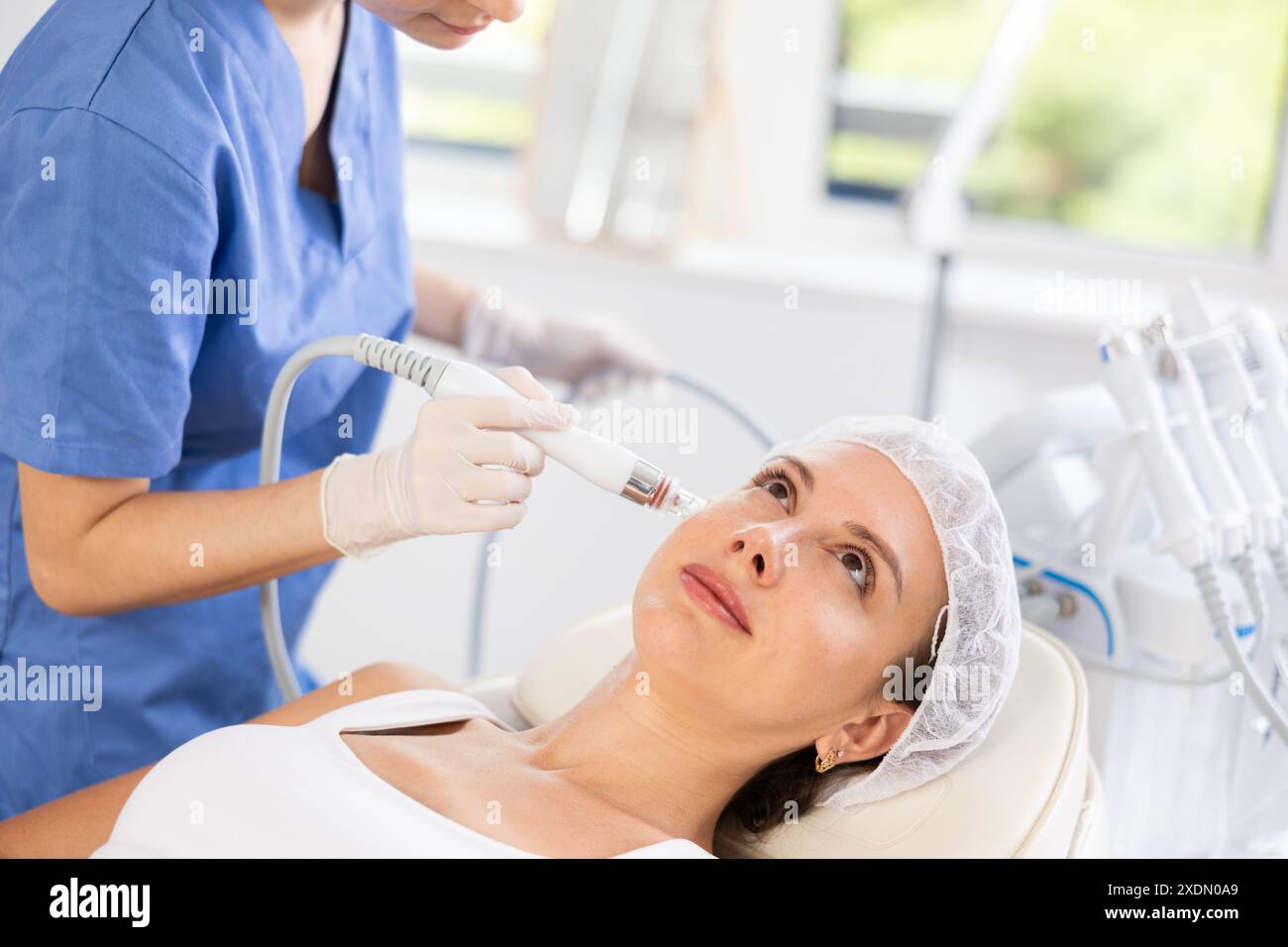 Woman receiving cosmetic facial procedure with hydrogen and oxygen ions ...