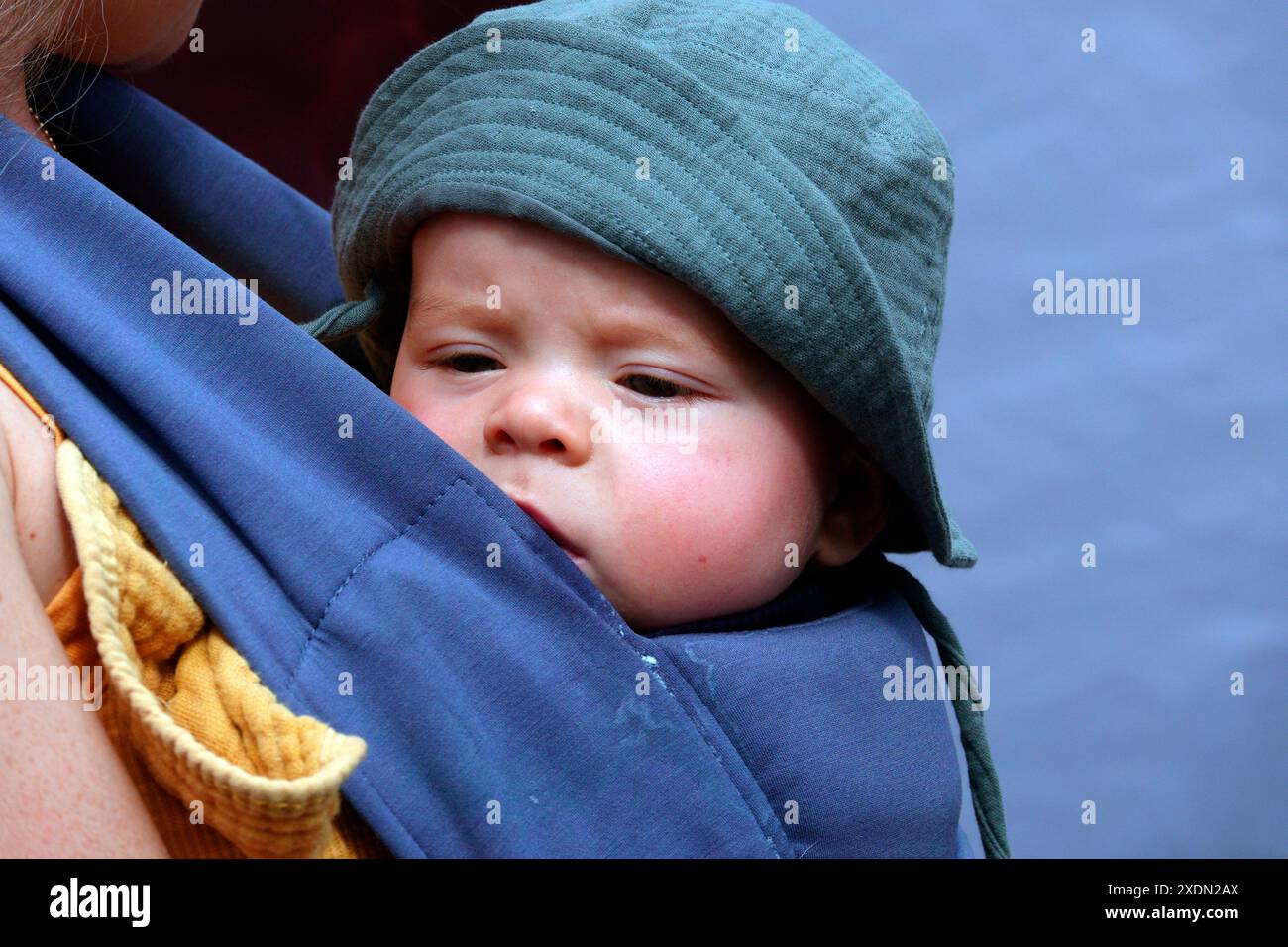 A woman carries her young son through the booths of a summer arts and ...