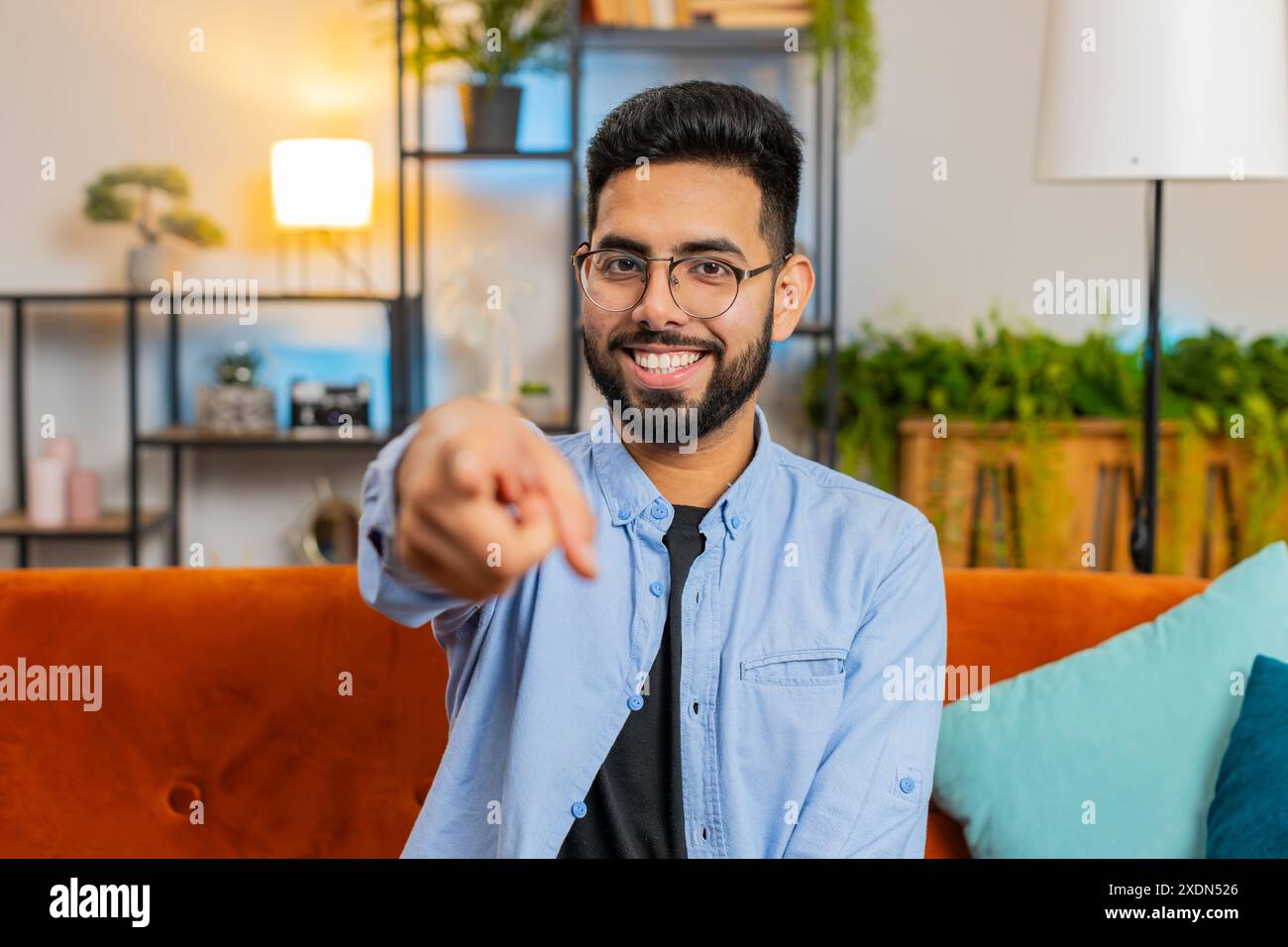 Hey you. Happy satisfied Indian man smiling and pointing to camera ...