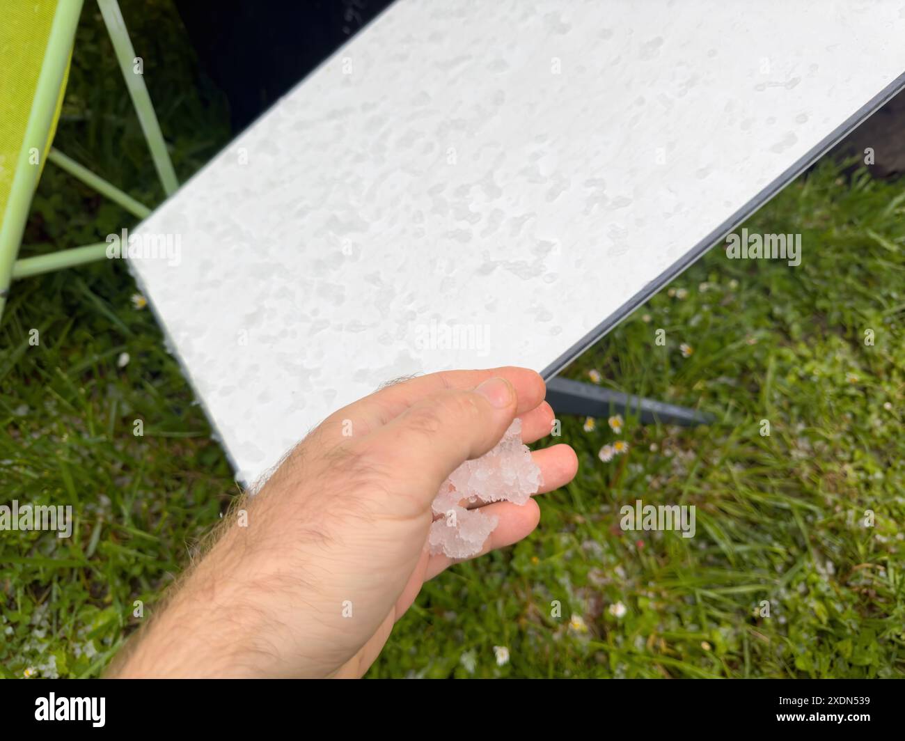 Frankfurt, Germany - Apr 21, 2024: A hand holding hailstones above a ...