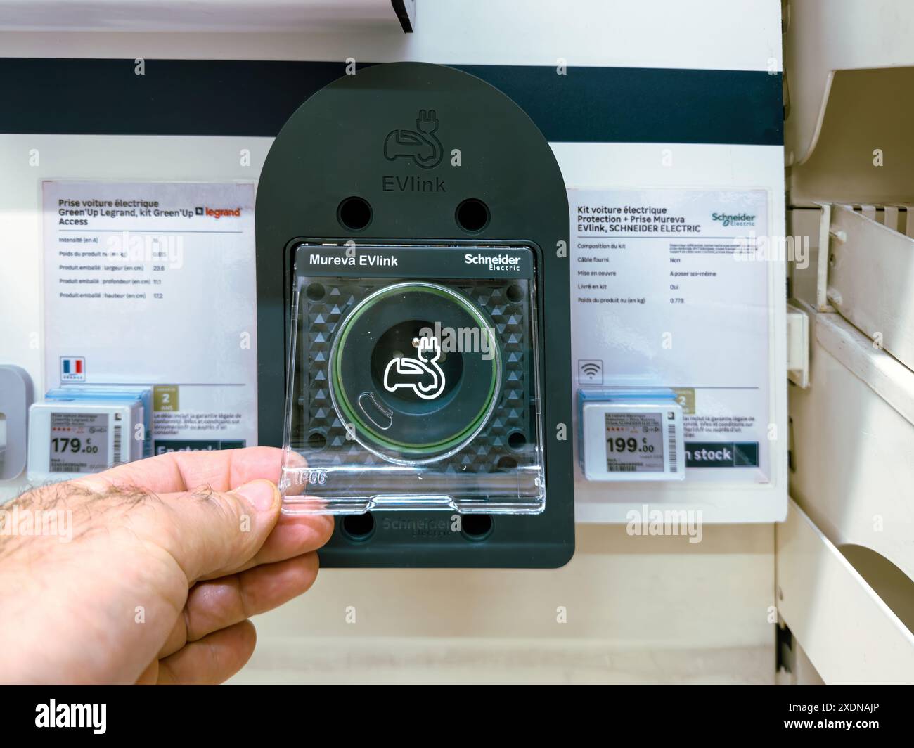 Paris, France - Apr 24, 2024: A hand holding a Schneider Electric ...