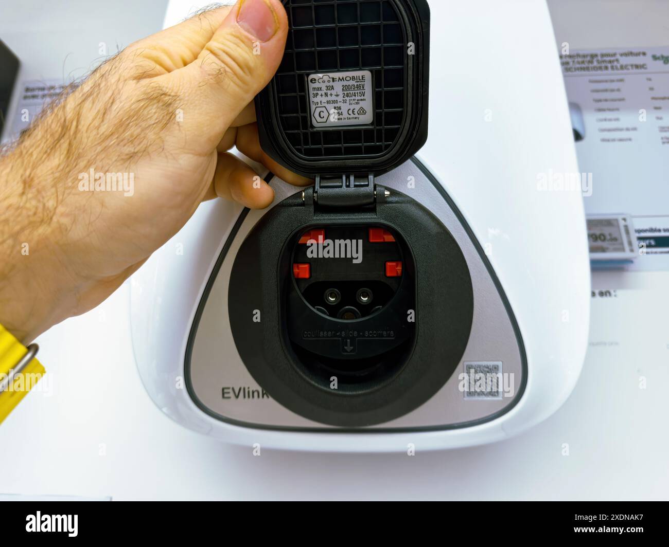 Paris, France - Apr 24, 2024: A hand opening the charging port of an ...