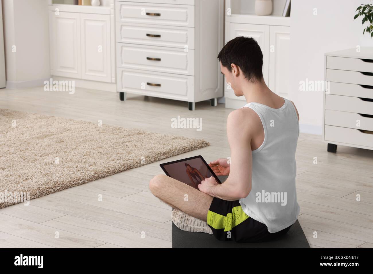 Online fitness trainer. Man watching tutorial on laptop indoors Stock ...