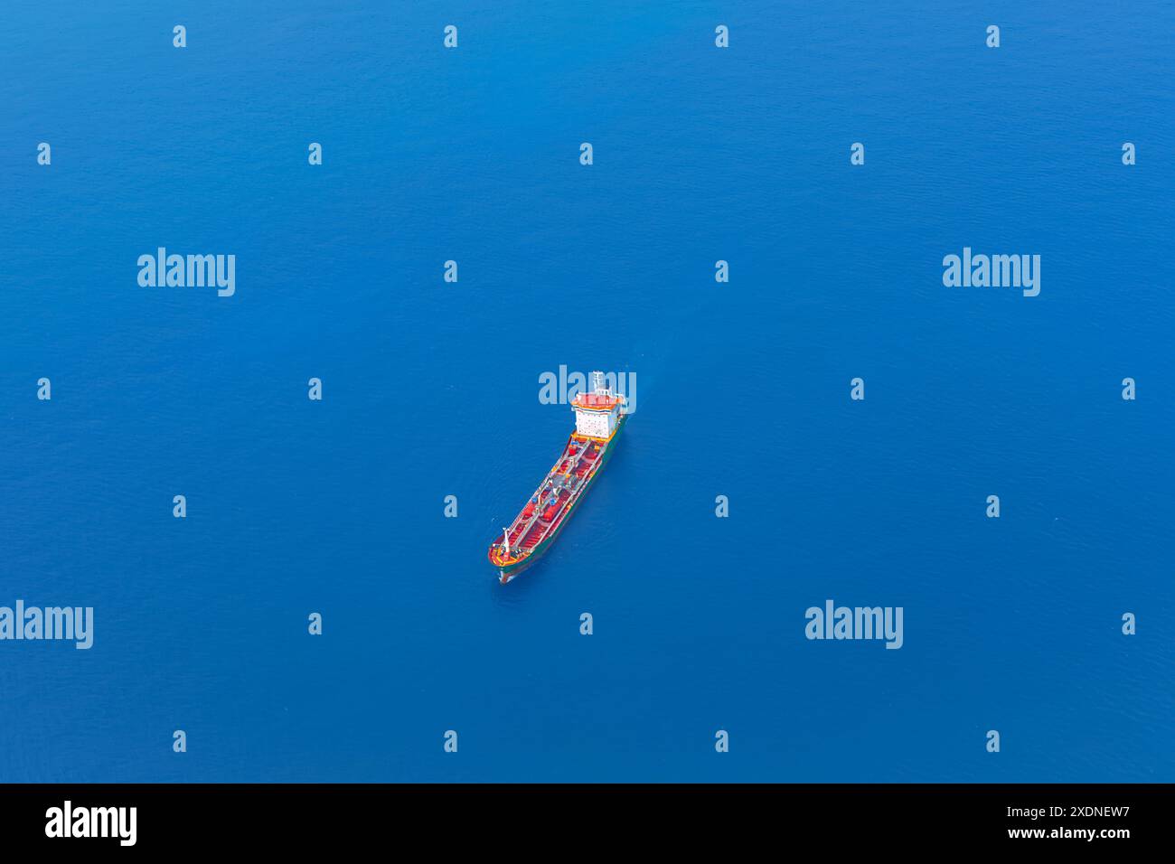 Aerial view of a cargo ship sailing in the vast ocean. The ship is the ...