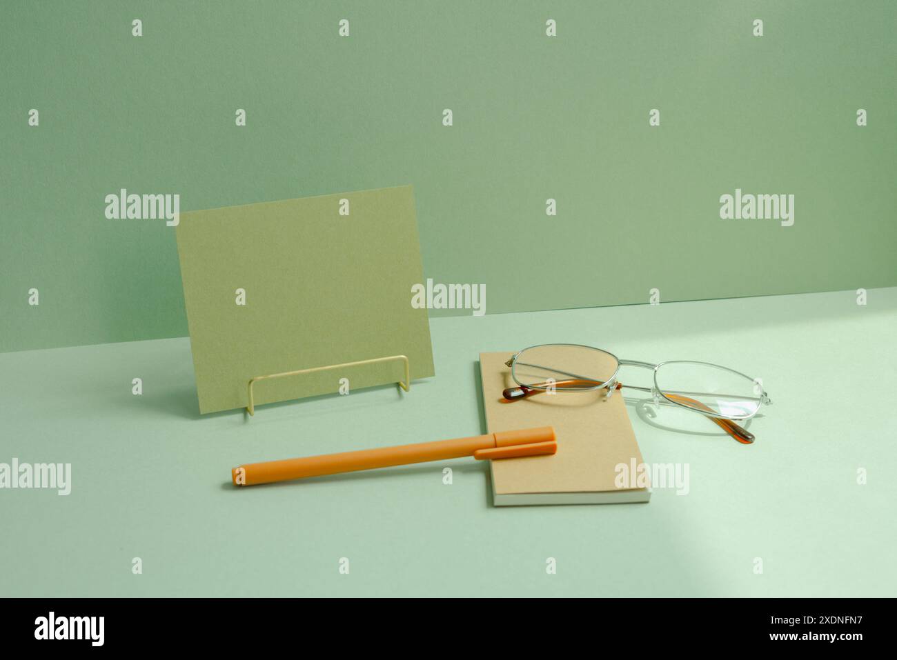 Workspace note, memo pad, eyeglasses, pen on mint green desk background ...