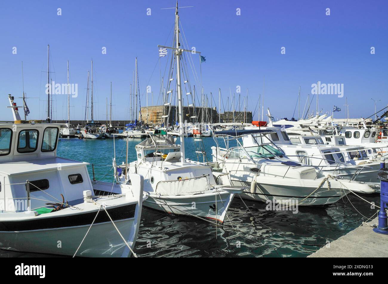 Sailing boats in front of ancient fortress under deep blue sky in the ...