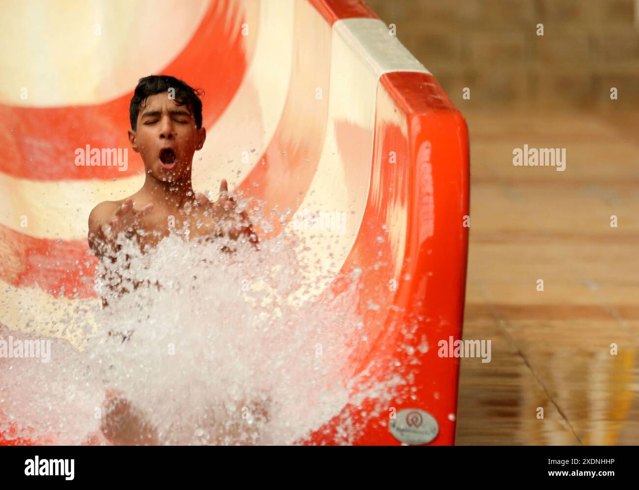 Baghdad, Iraq. 23rd June, 2024. A man cools himself at a water park in ...