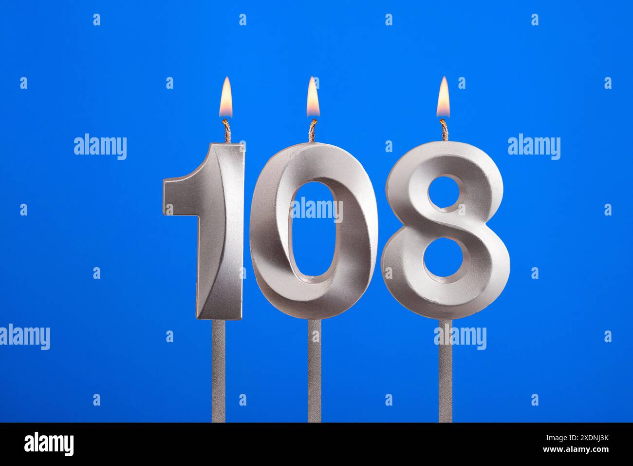 Birthday number 108 - Candle lit on blue background Stock Photo - Alamy