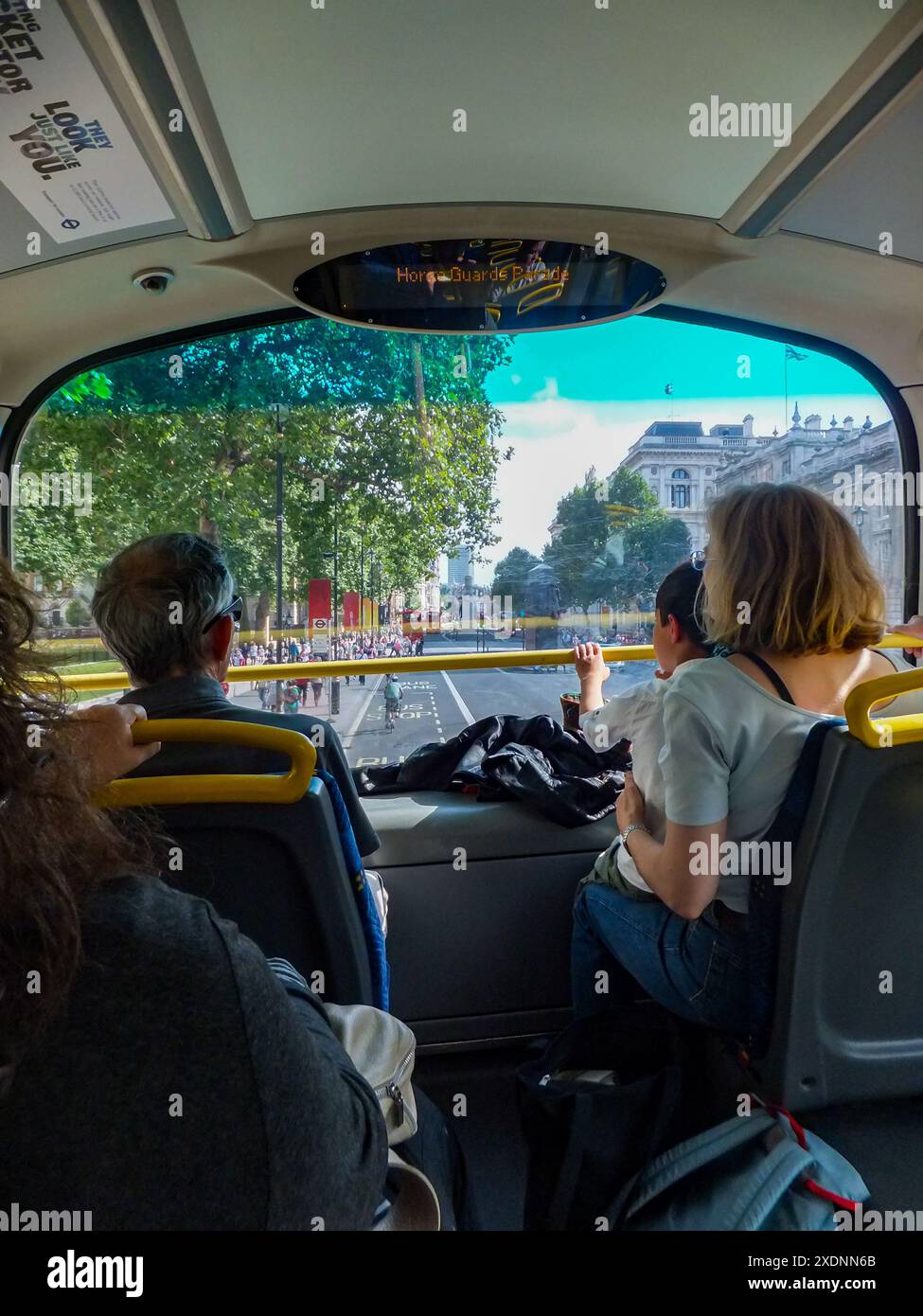 A family sits at the front of the upper deck of an iconic double decker ...