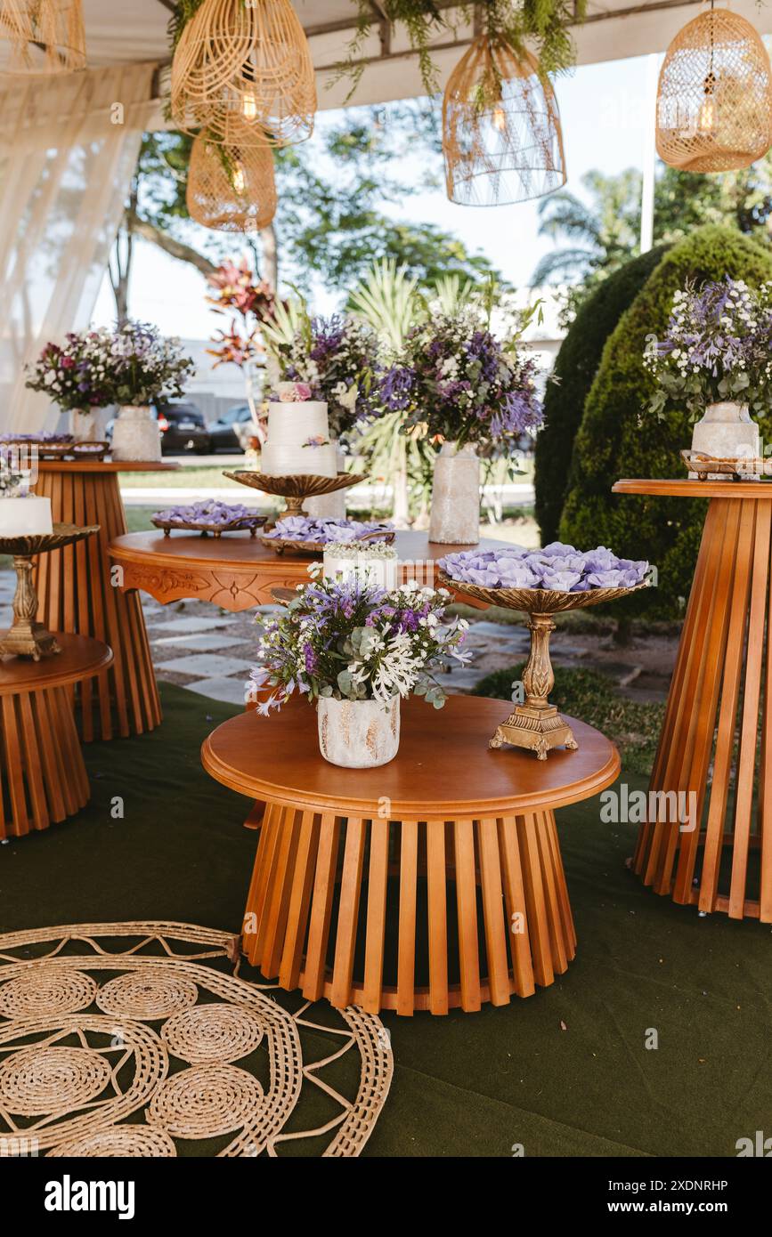 A beautifully decorated outdoor event setup with wooden tables, floral ...
