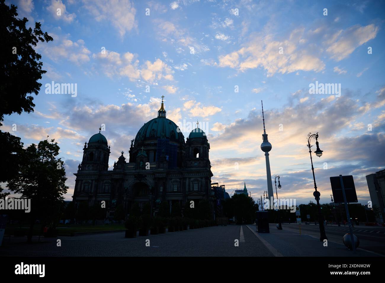 24 June 2024, Berlin: The rising sun illuminates the clouds above ...