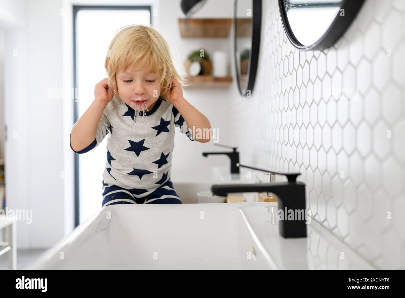 Boy spitting toothpaste and water after brushing his teeth. Morning ...