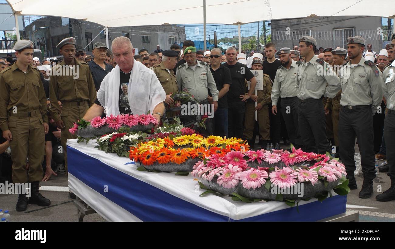 BEIT JAAN, ISRAEL - JUNE 16: Family members lay wreaths on the flag ...