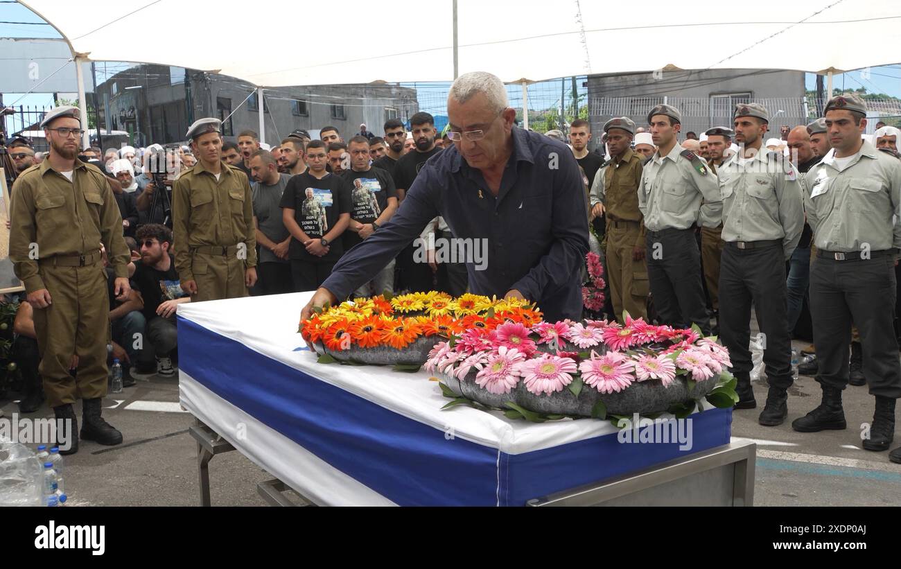 BEIT JAAN, ISRAEL - JUNE 16: Family members lay wreaths on the flag ...