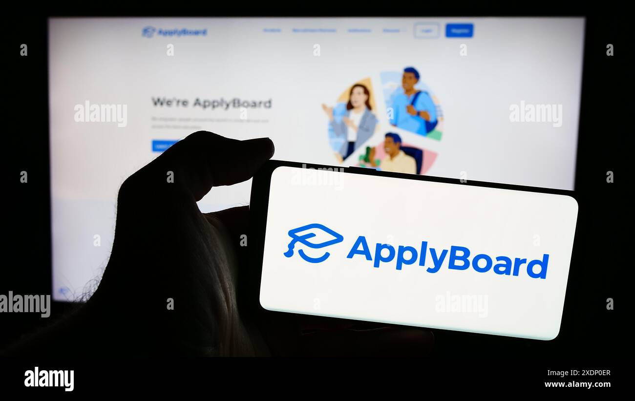 Person holding mobile phone with logo of Canadian educational technology company ApplyBoard Inc ...