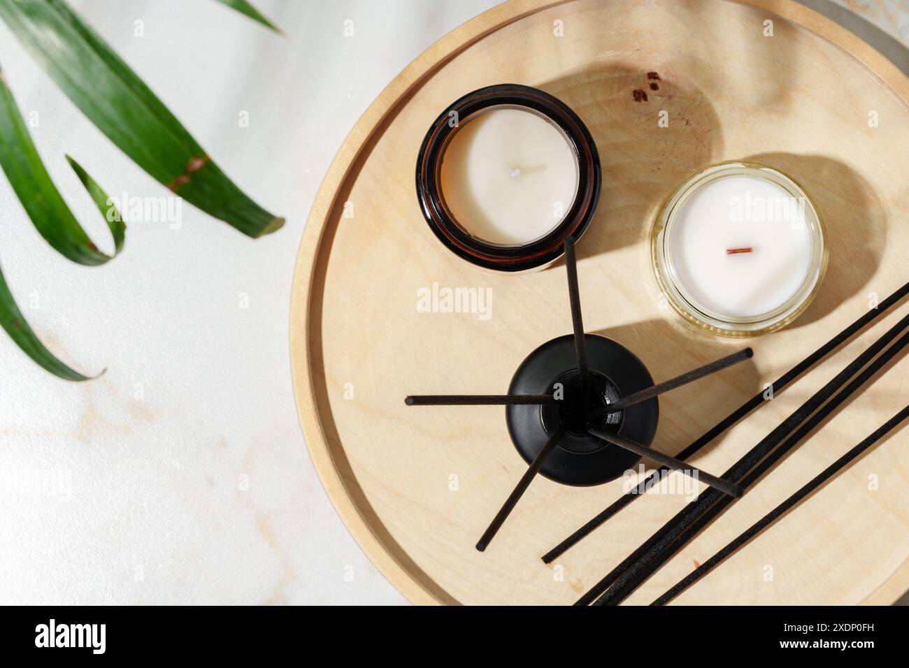 Black Reed Diffuser, Amber Candle, and Wooden Tray on White Surface ...