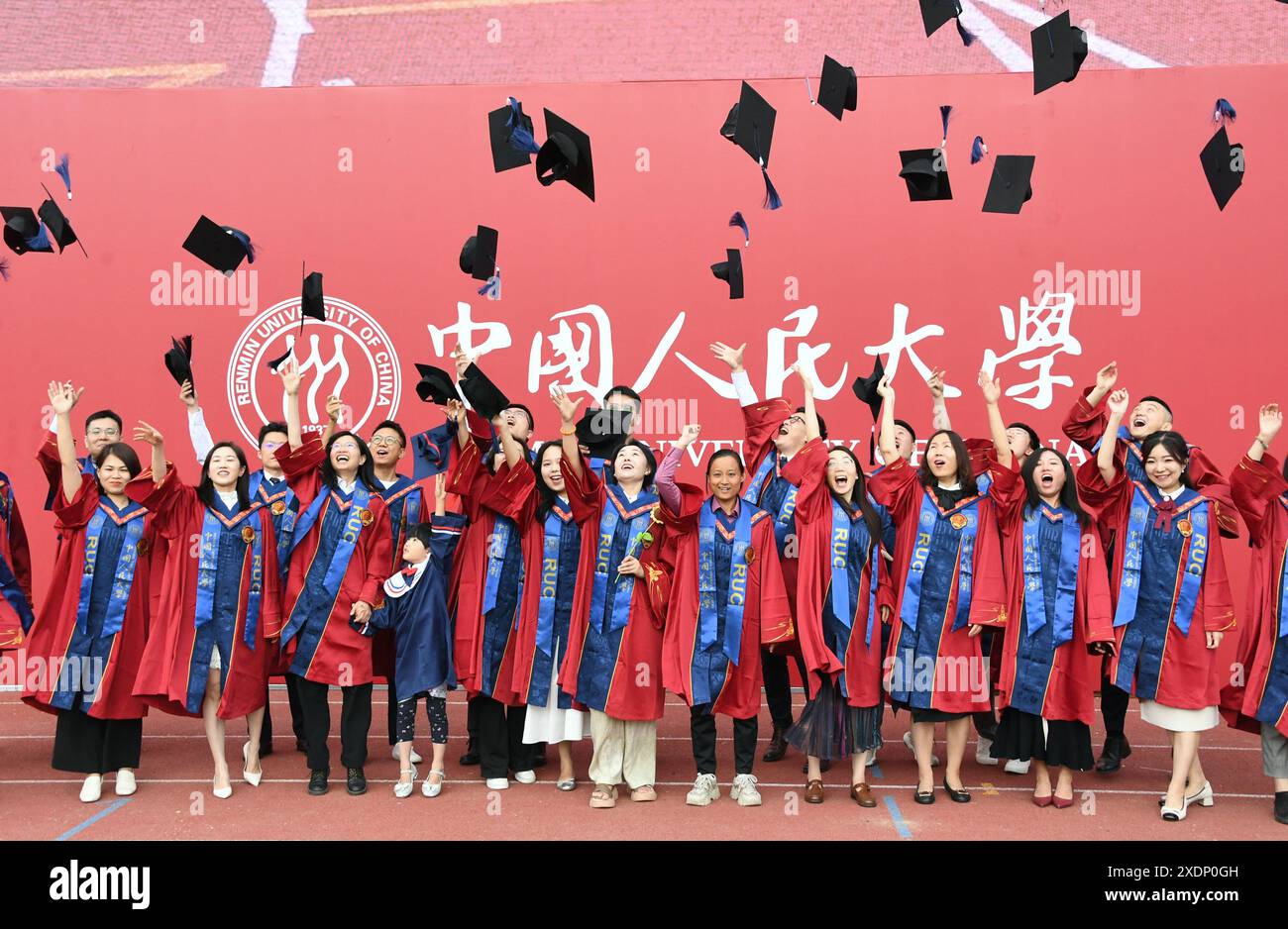Beijing, China. 23rd June, 2024. Graduates throw their hats in the air ...