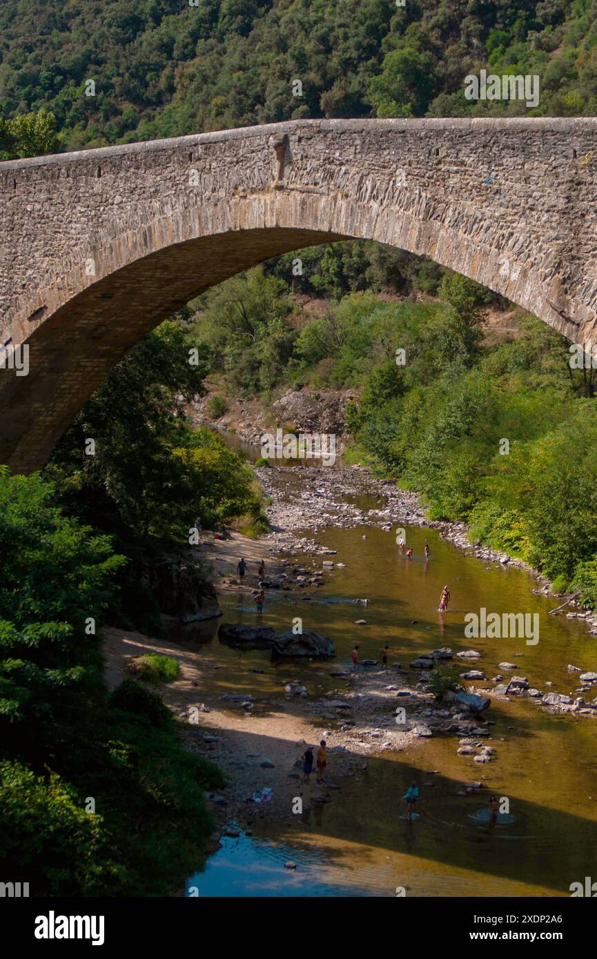 People bathing in river under bridge crossing the Gorges du Doux ...