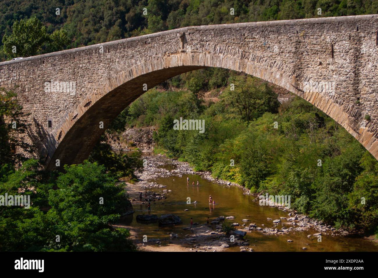 People bathing in river under bridge crossing the Gorges du Doux ...