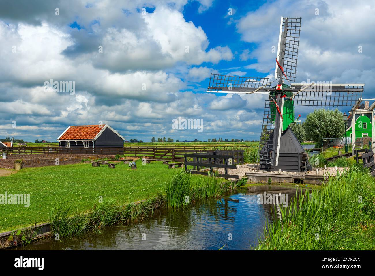 Small creek, windmill and rural house under beautiful sky in the famous ...