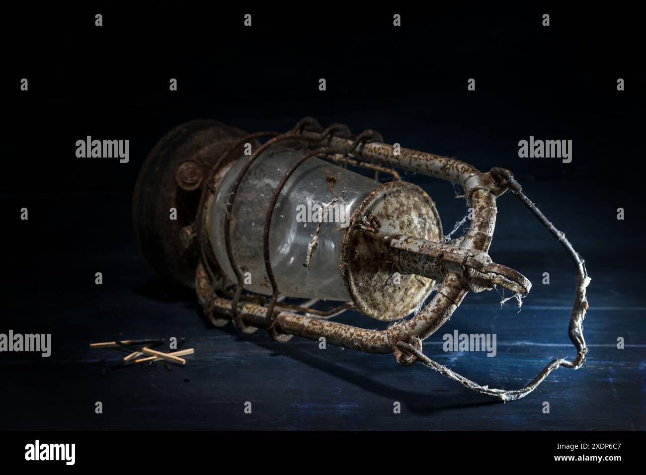 Outdated rusty kerosene lamp and some burnt matches lying on rustic ...