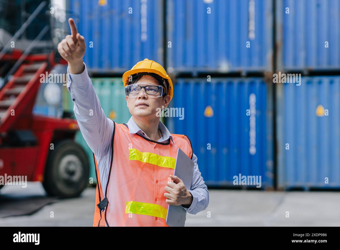 Success male worker standing hand point high for order operate control work in cargo shipping ...