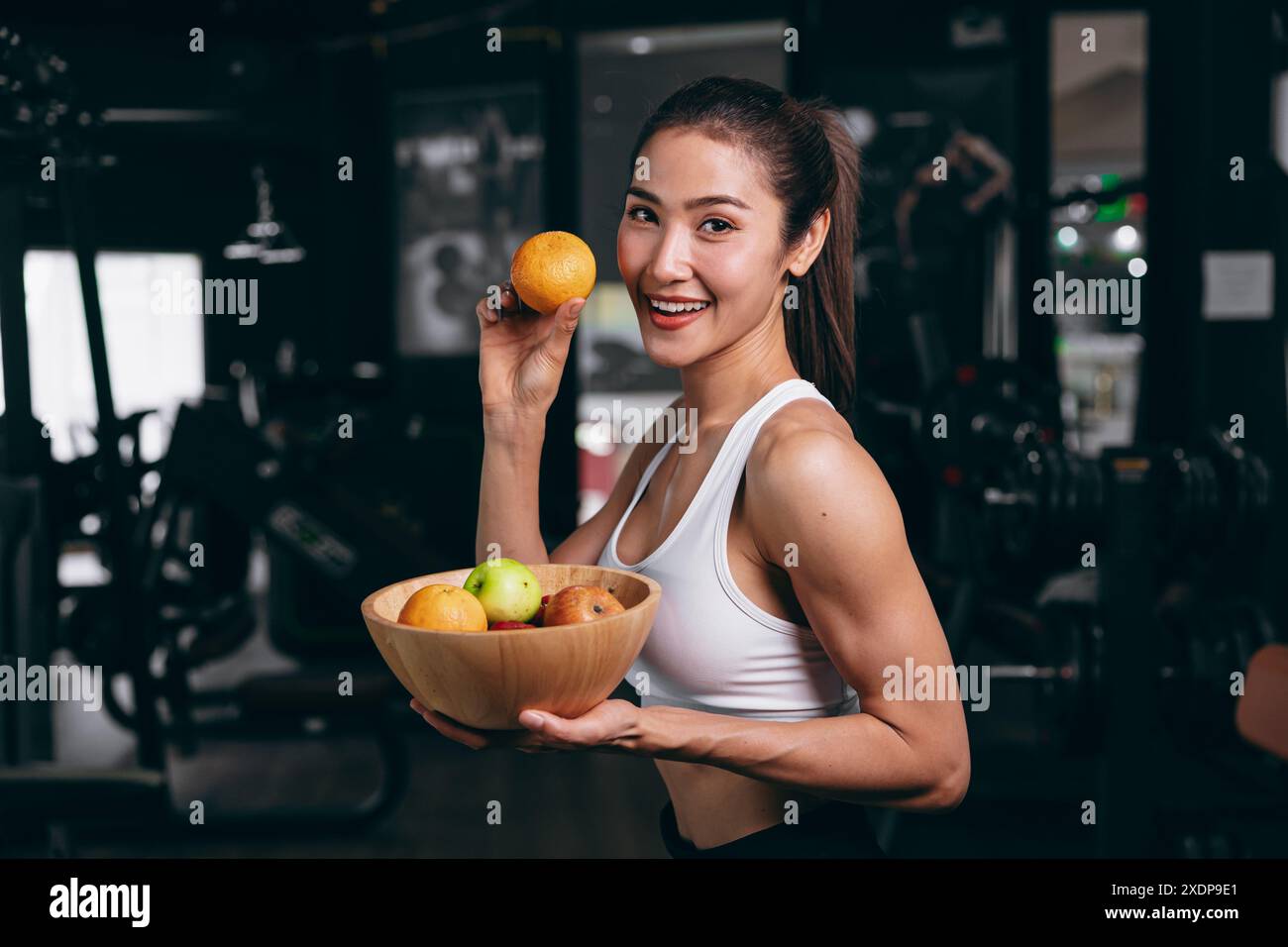 Healthy women in Fitness Gym Body Care by Eating Mix Fruits and weight ...