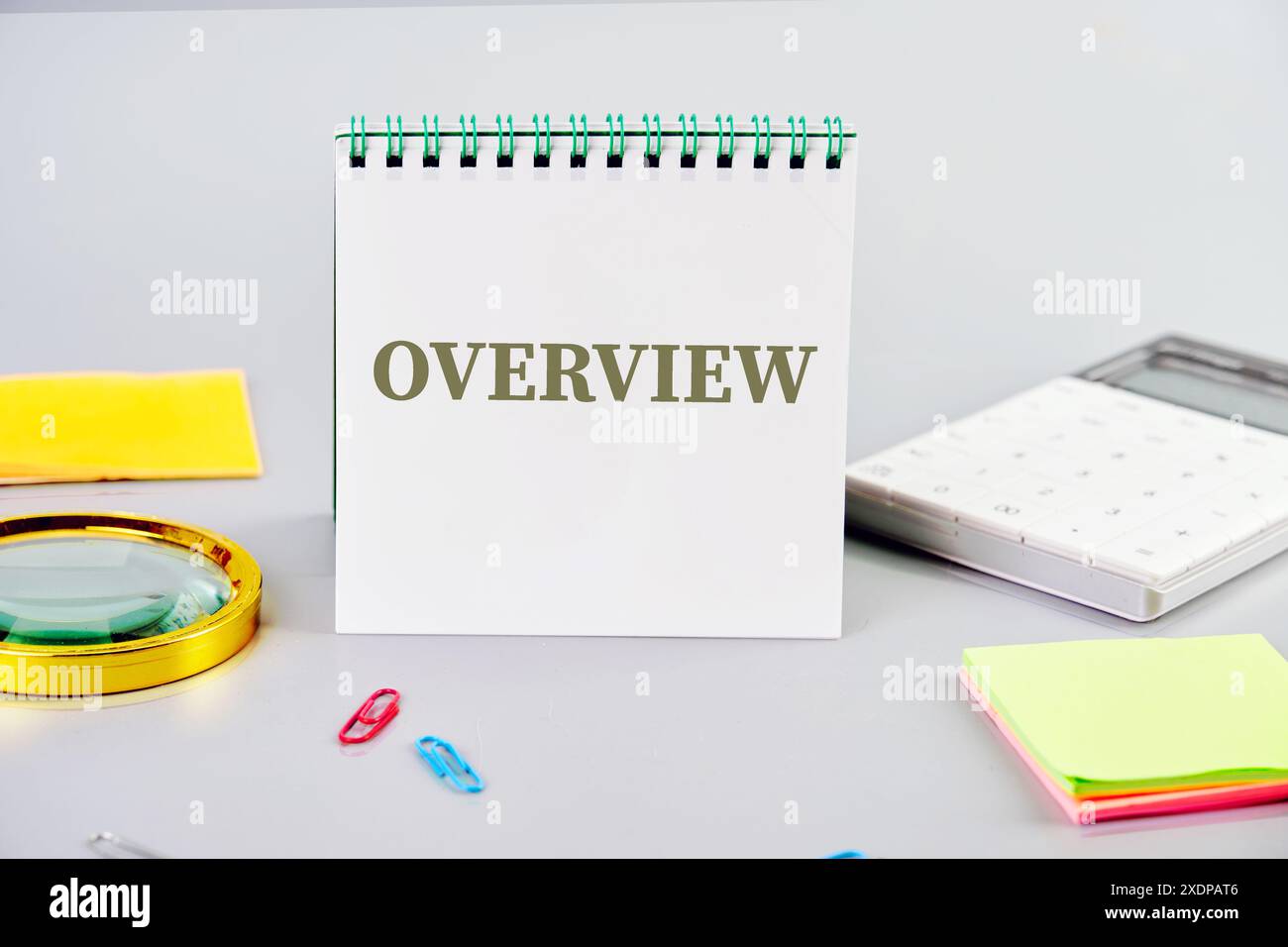 OVERVIEW text in a notebook next to a magnifying glass, calculator ...
