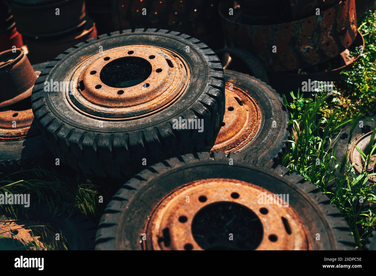 Old worn tires and rusty vehicle wheel rims on dump ground, selective ...