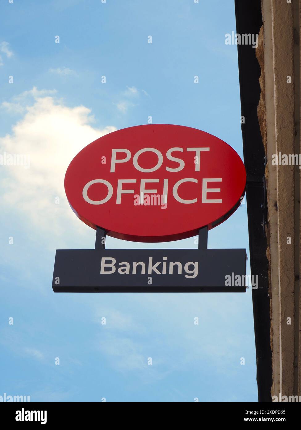 Red British or UK Post Office and banking sign mounted on wall above ...