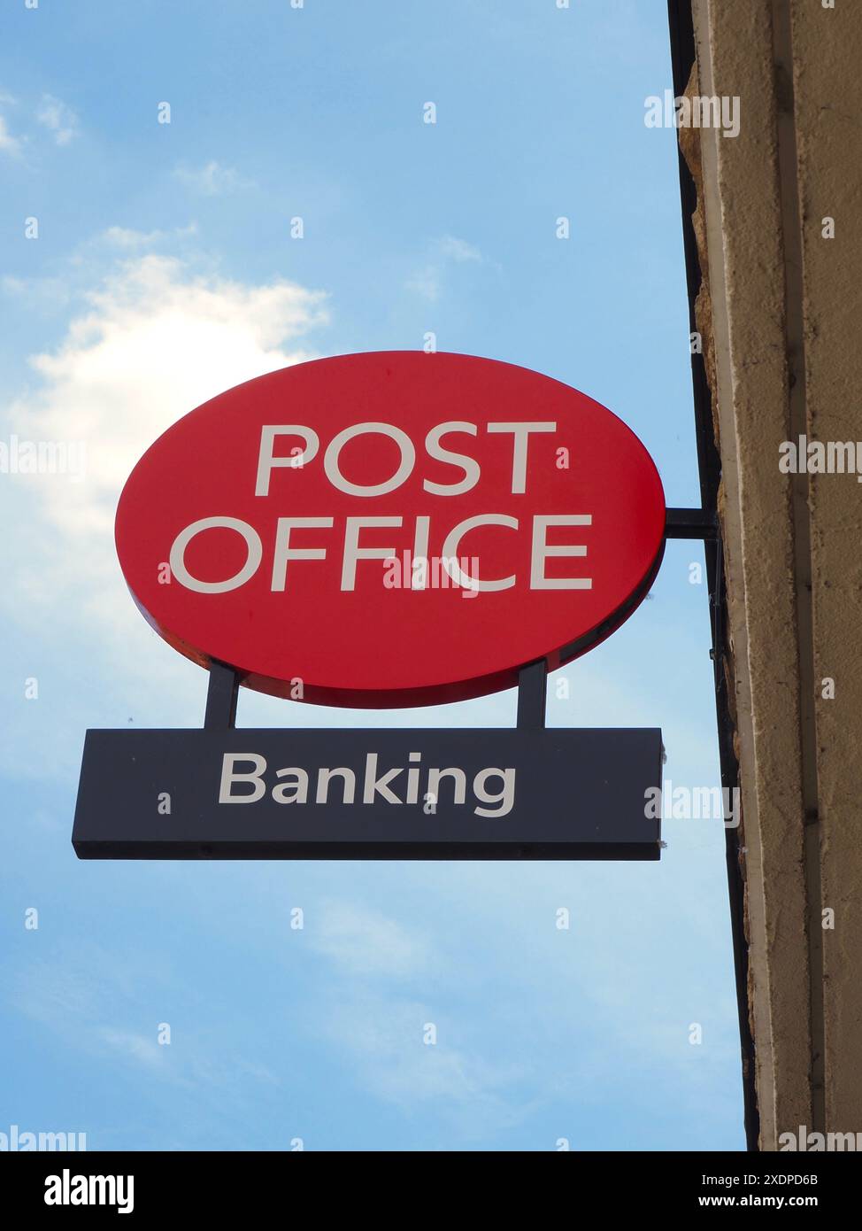 Red British or UK Post Office and banking sign mounted on wall above ...