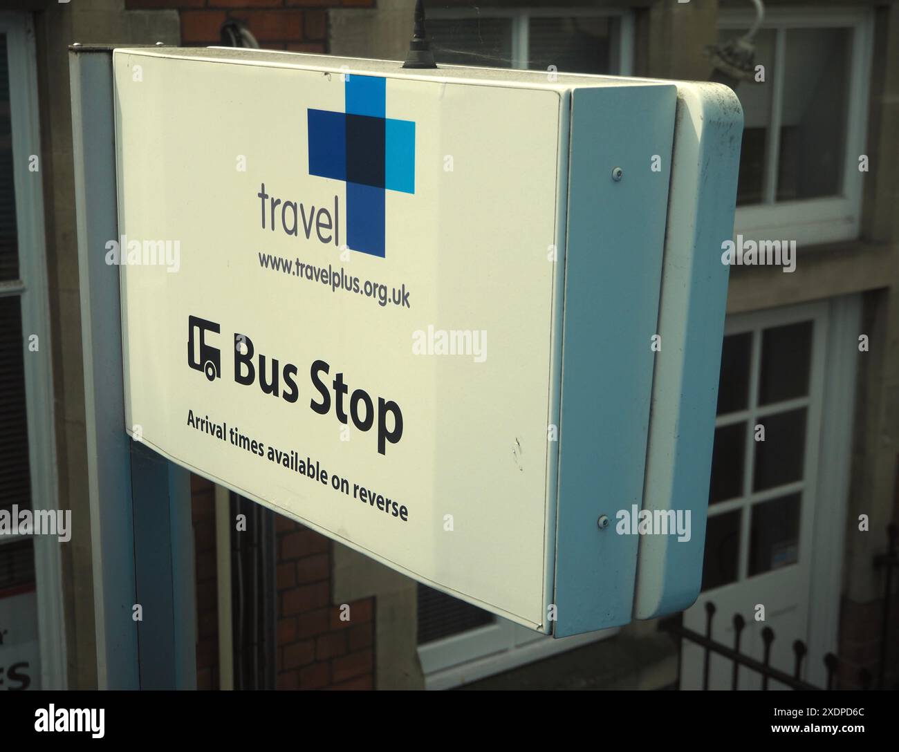 Wide angle shot of white travelplus.org.uk bus stop sign with blue ...