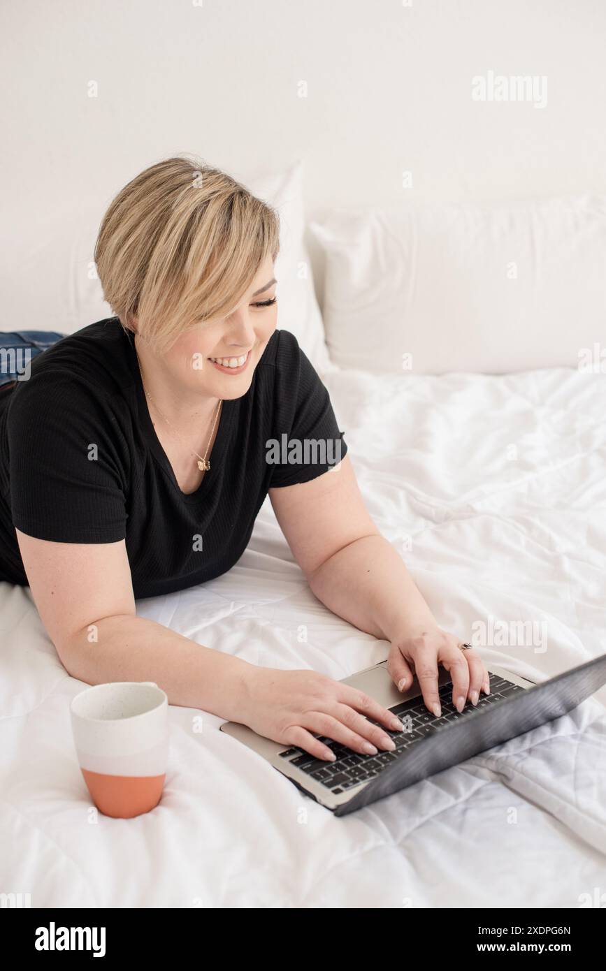 Women typing on laptop bed hi-res stock photography and images - Alamy