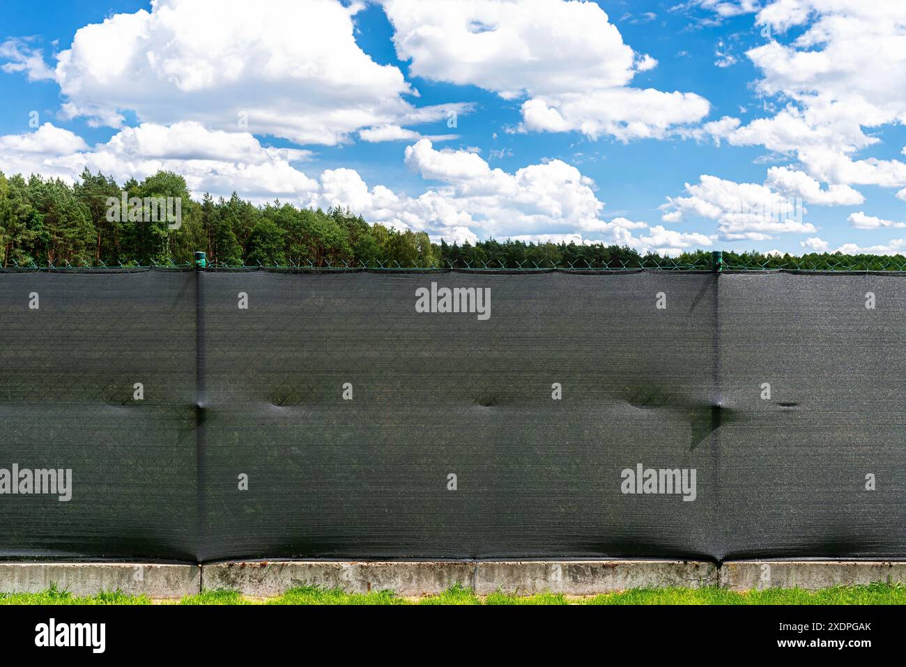 Anthracite-colored masking net placed on a mesh fence, visible garden ...