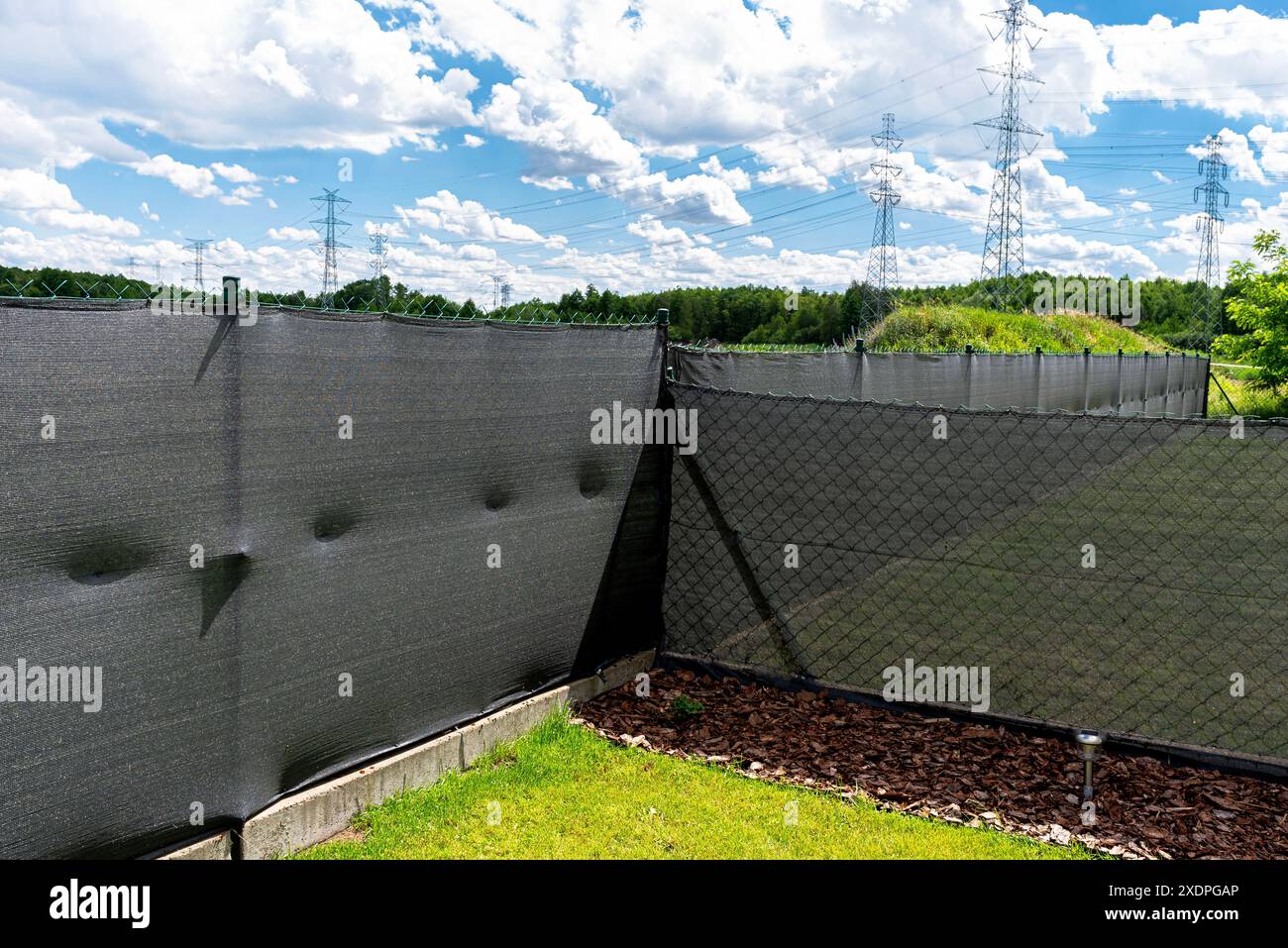 Anthracite-colored masking net placed on a mesh fence, visible pine ...