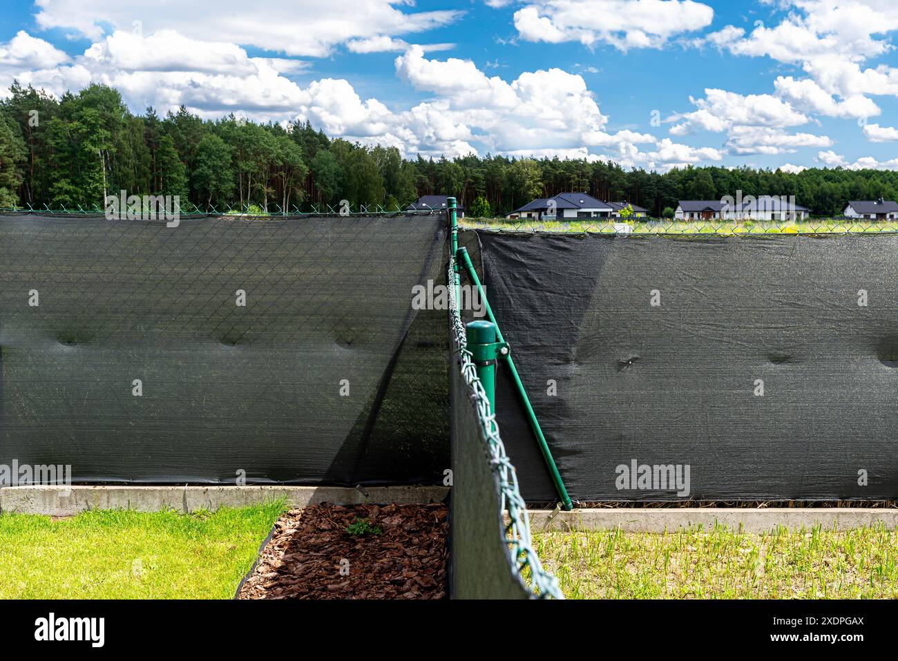 Anthracite-colored masking net placed on a mesh fence, visible pine ...