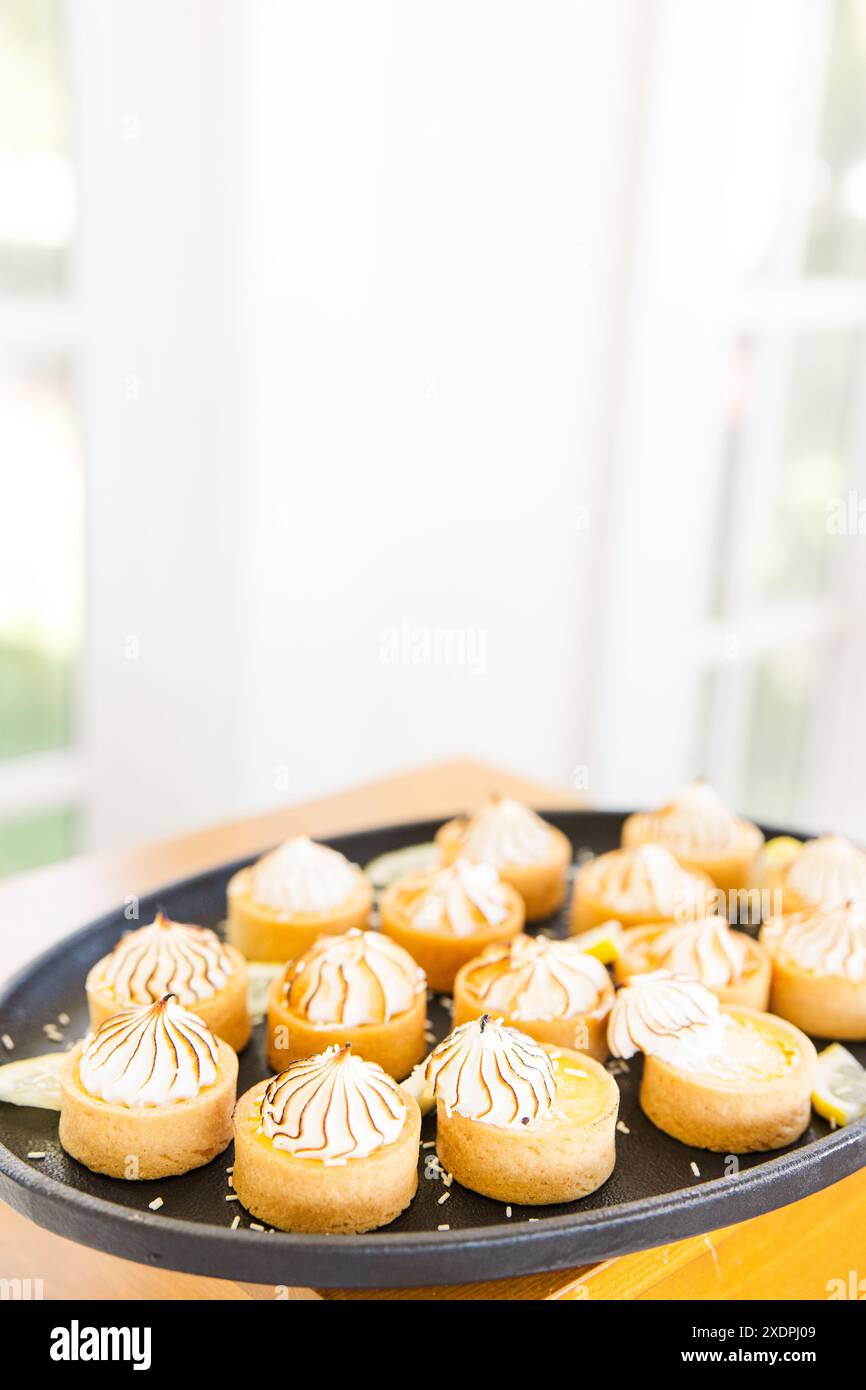 Plate of lemon meringue tarts in a bright, elegant setting Stock Photo ...