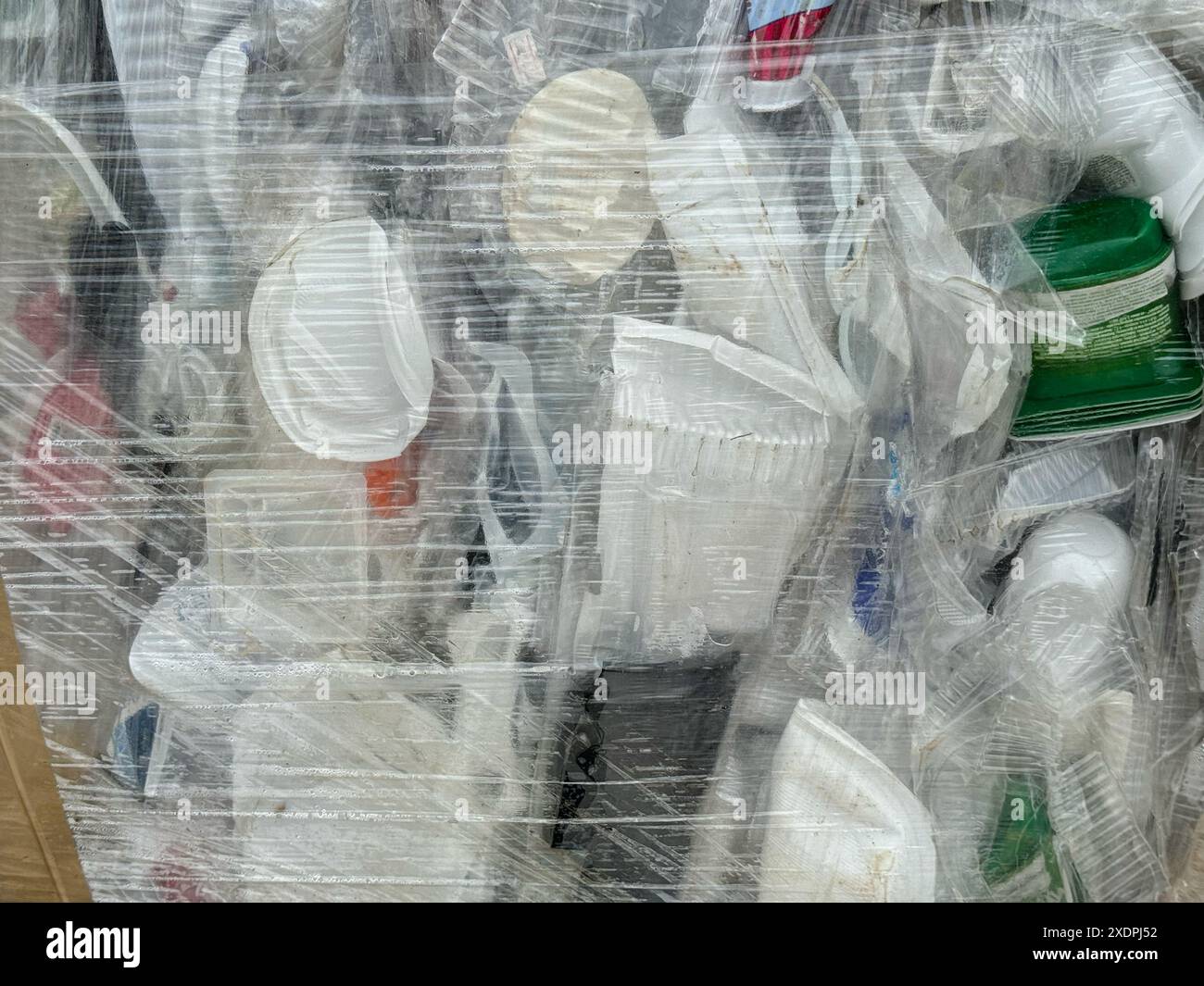 A bale of compressed plastic and Styrofoam packaging materials wrapped ...