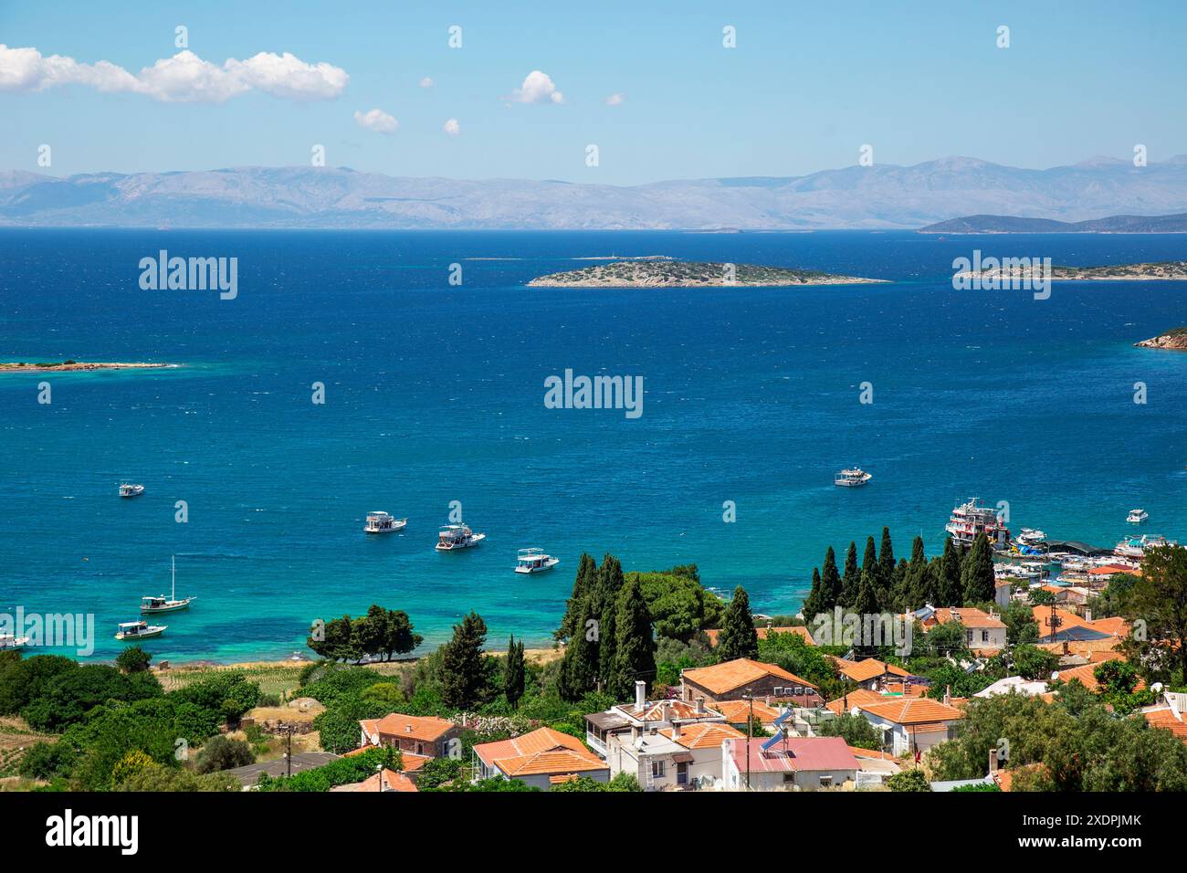 Scenic coastal view with clear cyan sea, fishing boats and islands ...