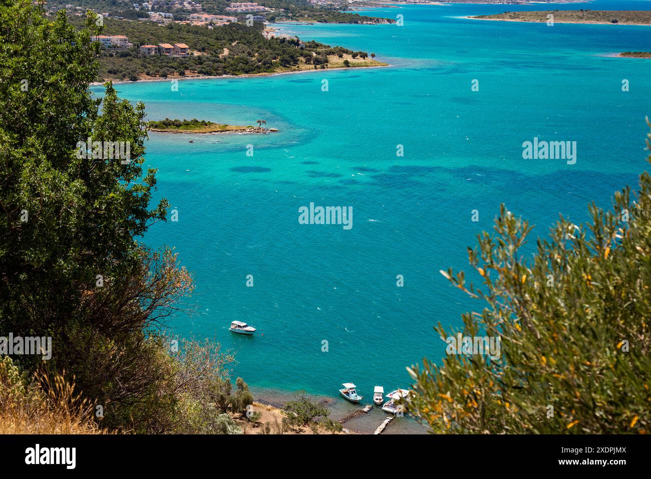 Scenic coastal view with clear cyan sea, fishing boats and islands ...
