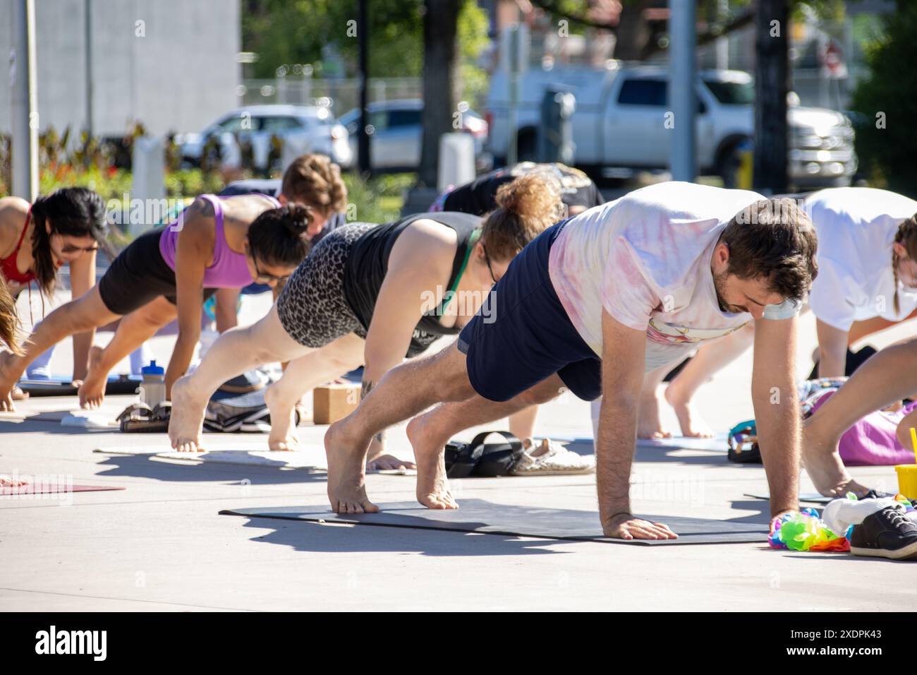 Group yoga class outdoors in plank position on sunny day Stock Photo ...