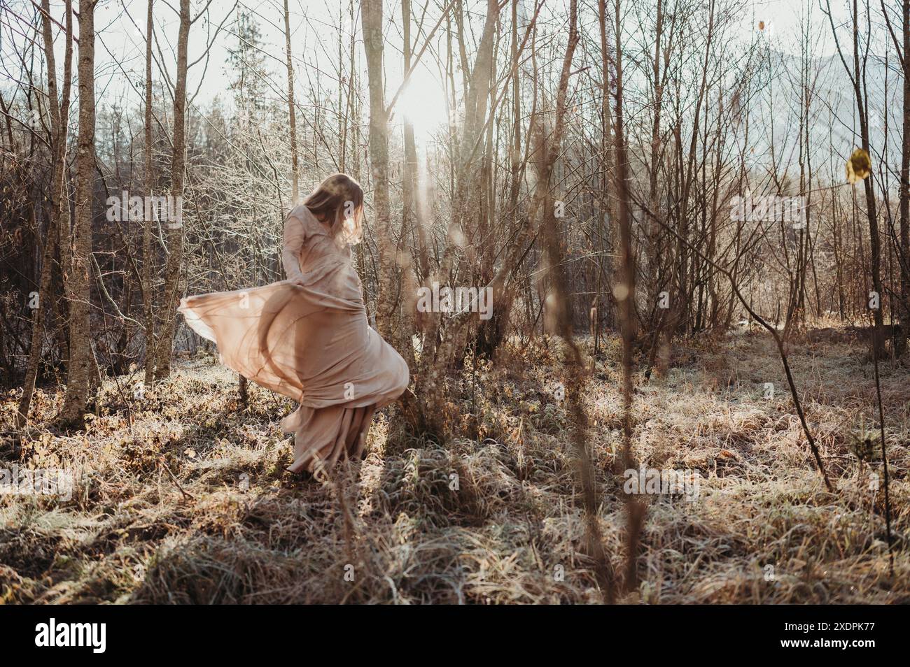 Woman in a dress twirling in the morning sun in nature Stock Photo - Alamy