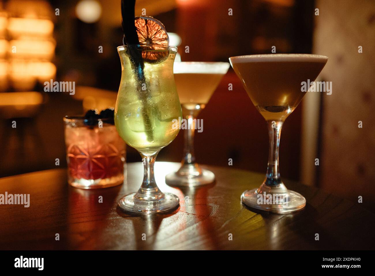 Assorted cocktails on a bar table in a dimly lit setting Stock Photo ...