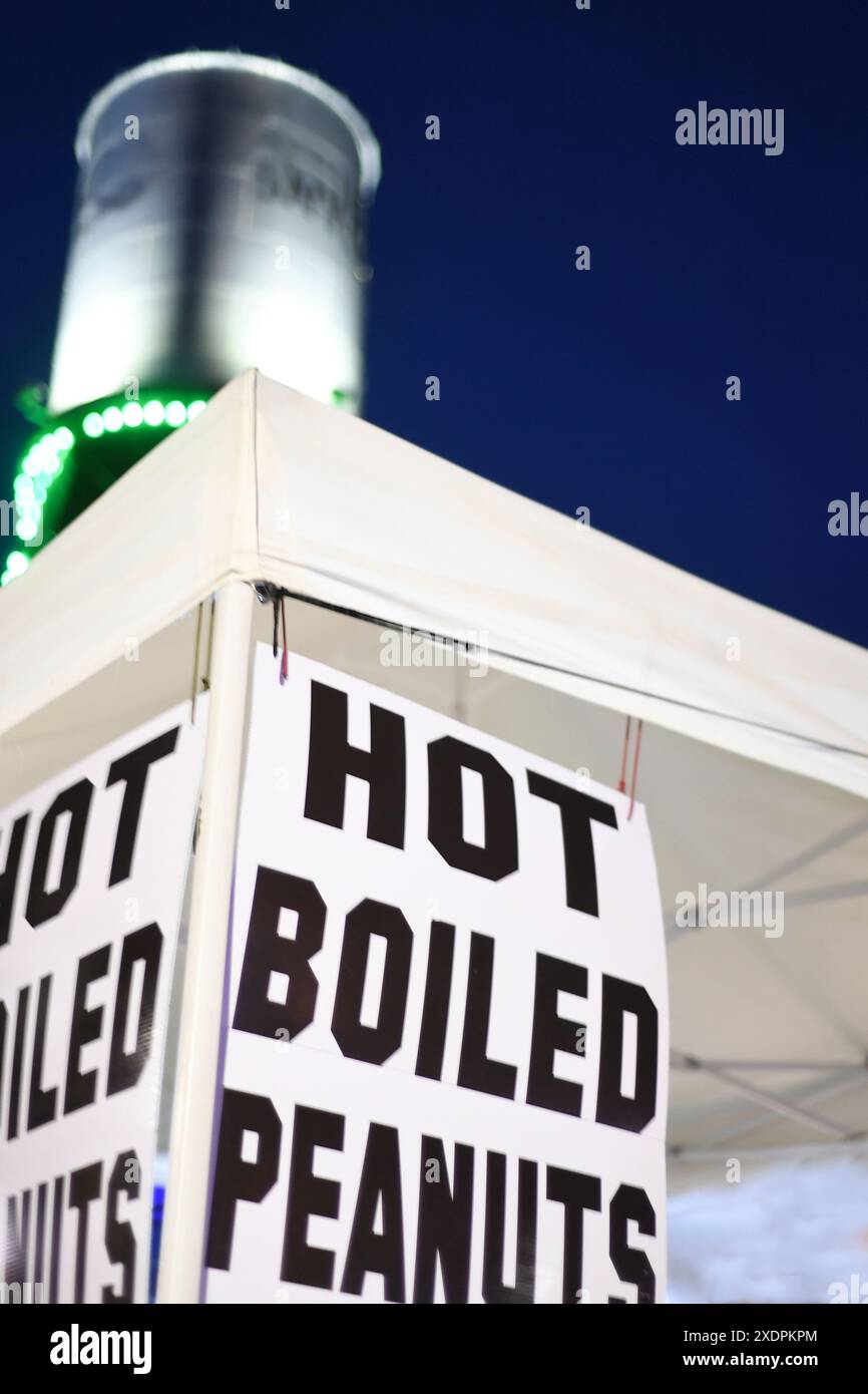 Hot boiled peanuts sign at a night market with a water tower in Stock Photo - Alamy
