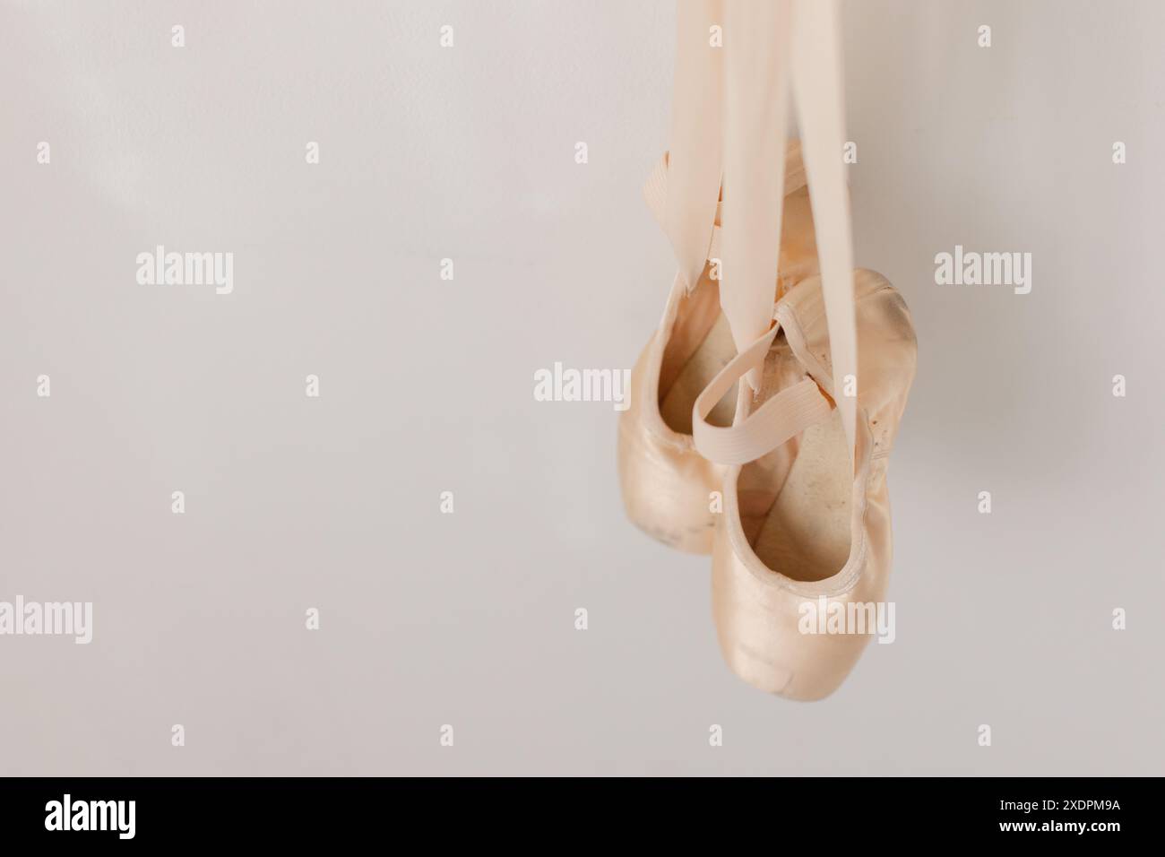 ballet pointe shoes hang from barre in white studio Stock Photo - Alamy