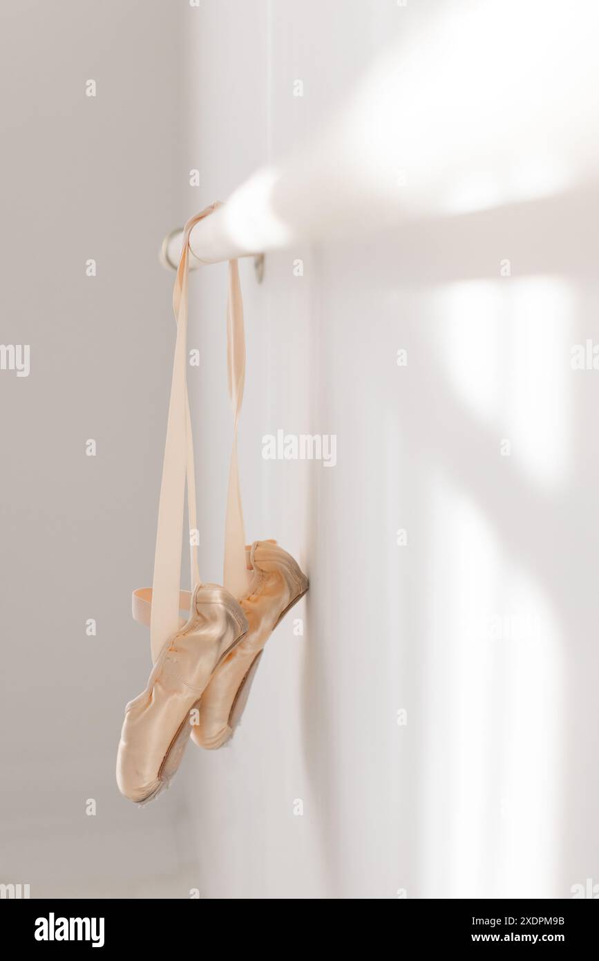 ballet pointe shoes hang from barre in white studio Stock Photo - Alamy