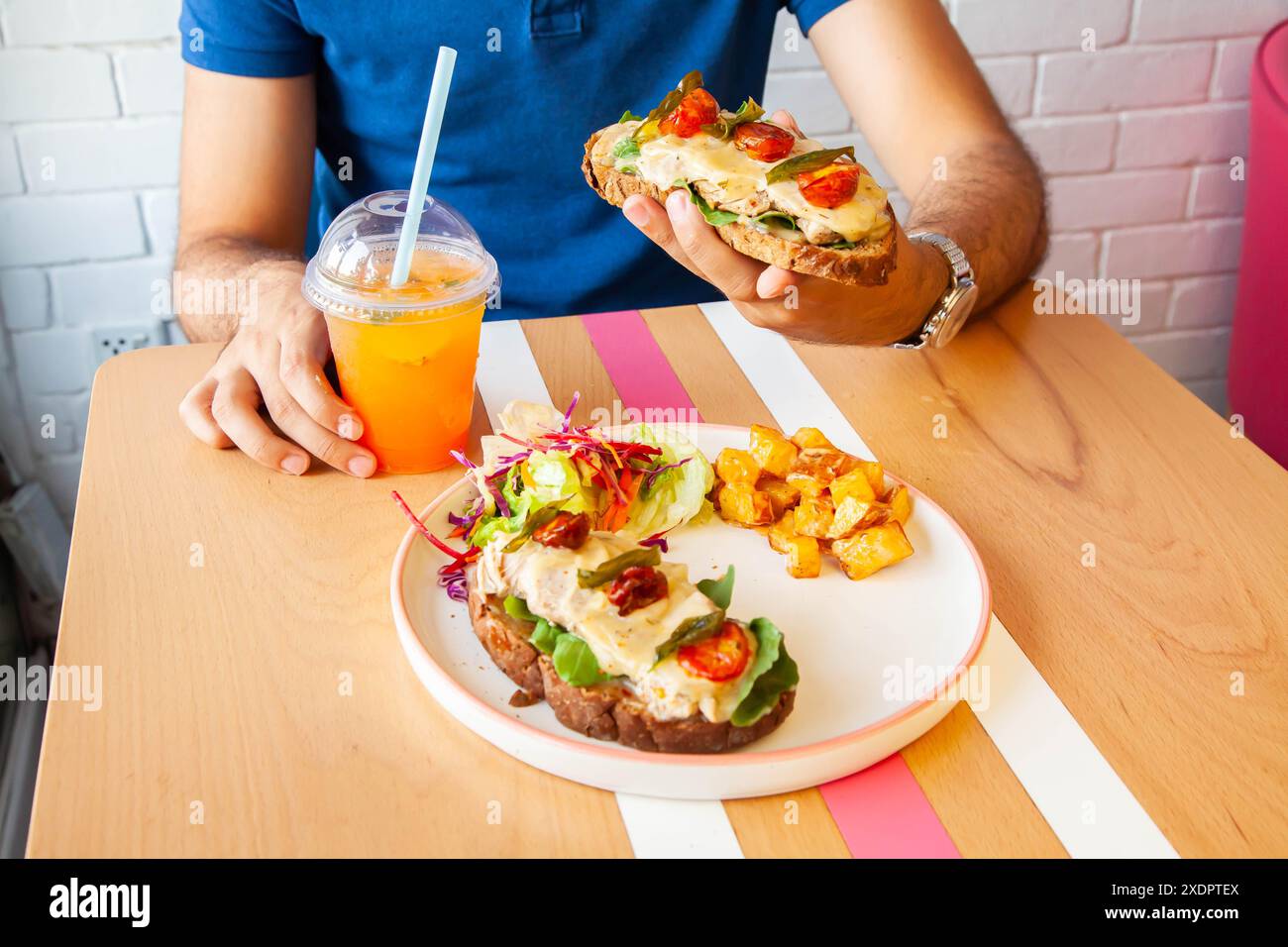 Male wearing blue shirt having brunch with orange drink and open faced ...