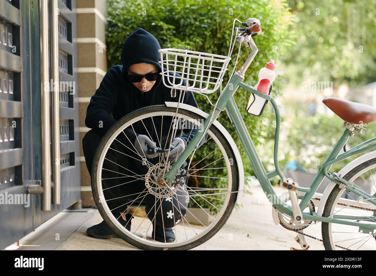 Thief In Black Stealing The Bike Stock Photo - Alamy