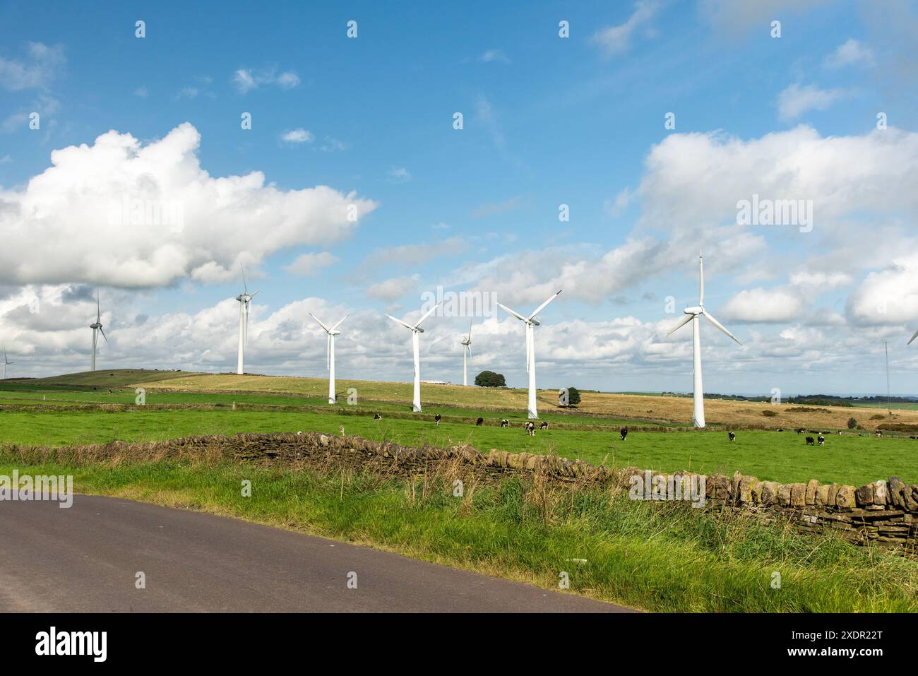 Low down view, looking up at a wind turbines, with two engineers ...