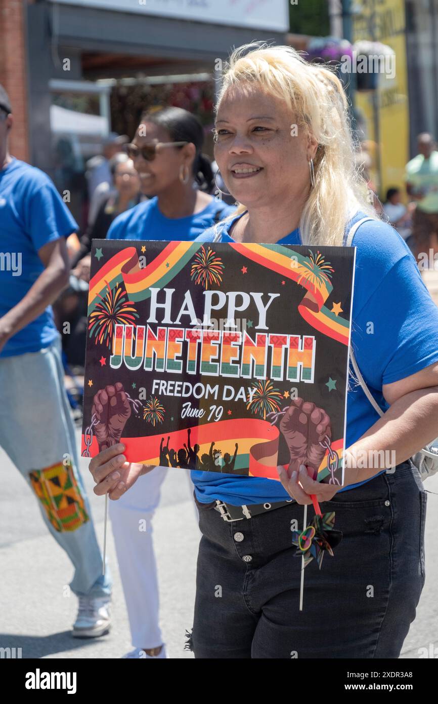 A marcher holding a Happy Juneteenth placard in the 2024 Peekskill ...